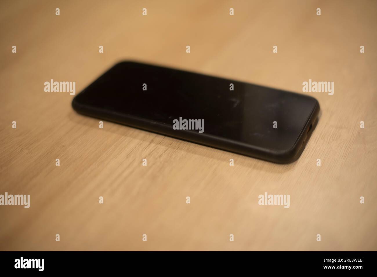 Smartphone on table. Black phone. Device lies on board. Old smartphone ...