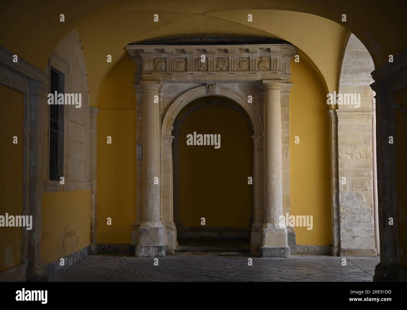 Antique Neoclassical style portal with Ionic columns on an arched ochre ...