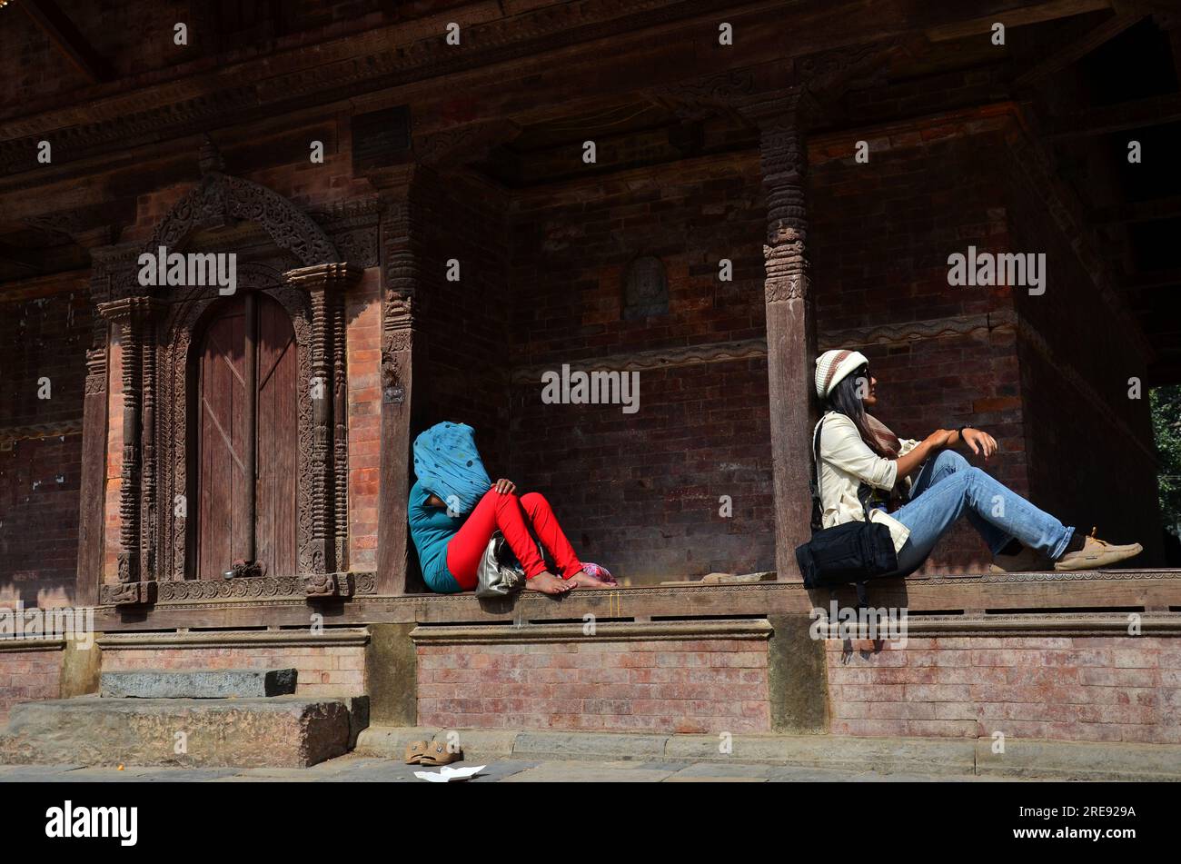 Life and lifestyle of nepali women sitting rest relax on floor of ancient nepalese architecture ...