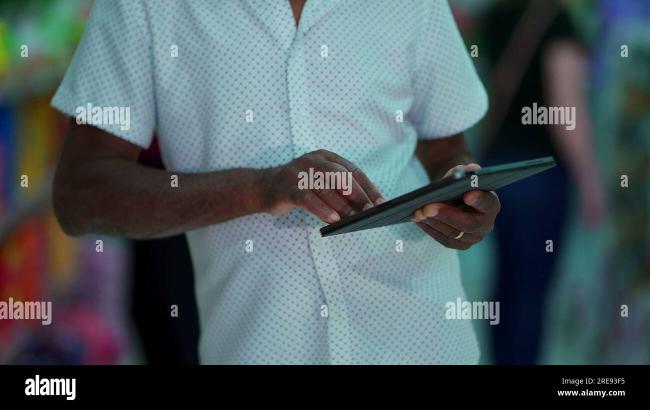 Close-up of a senior black man hands holding tablet device. Elderly ...