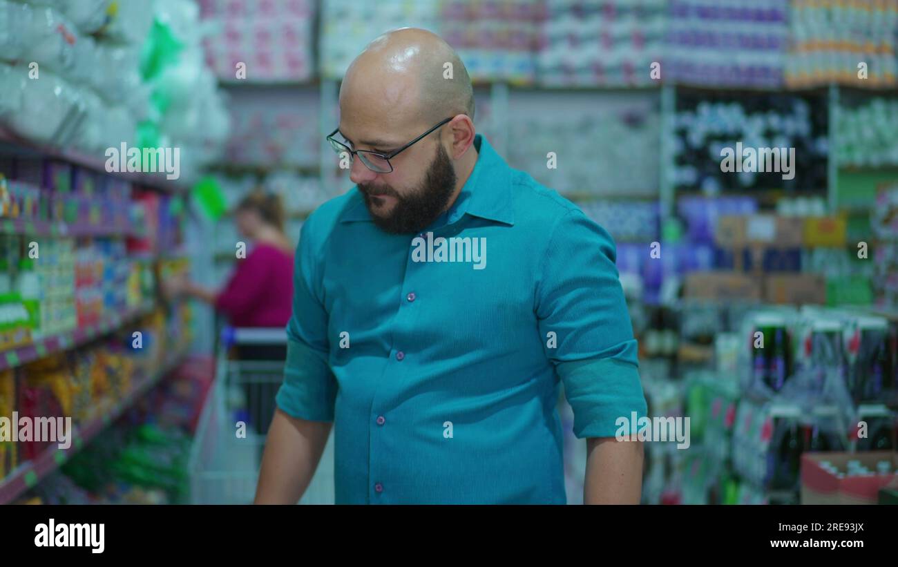 Customer looking at products in supermarket aisle. Person shopping ...