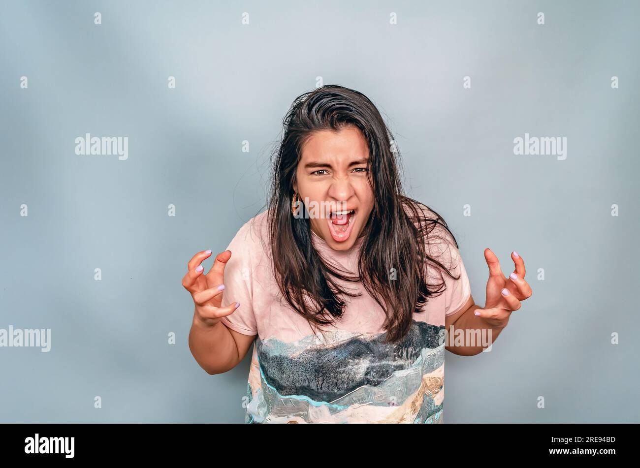Angry woman screams. Latin American woman emotionally shows her anger ...