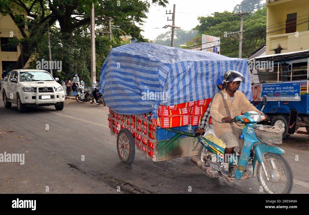 people move transport goods for sale, man drives laden motorcycle ...