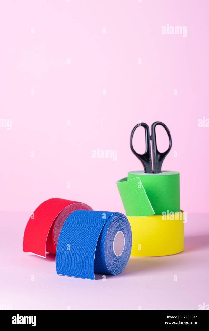 Colorful kinesiology tapes and scissors on pink background, kinesiology ...