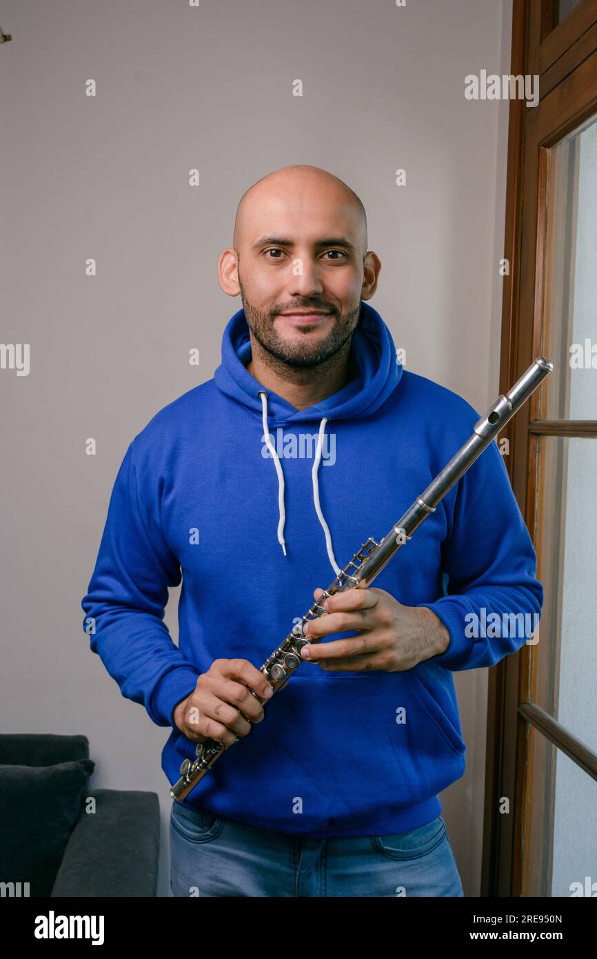 vertical portrait of young latino man with beard and bald, dressed in ...