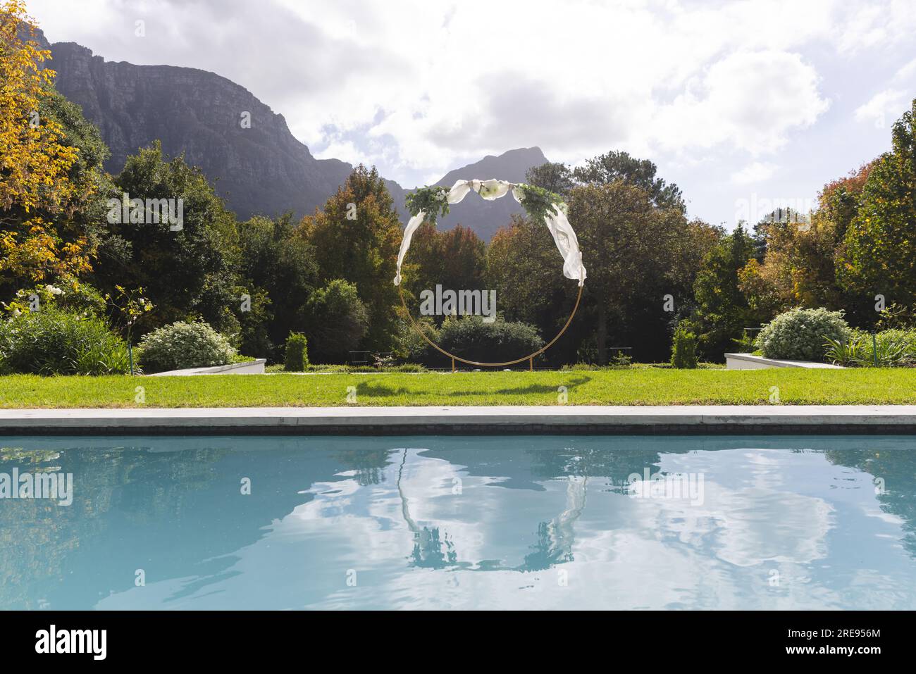Decorative wedding arch by swimming pool in sunny garden, copy space ...