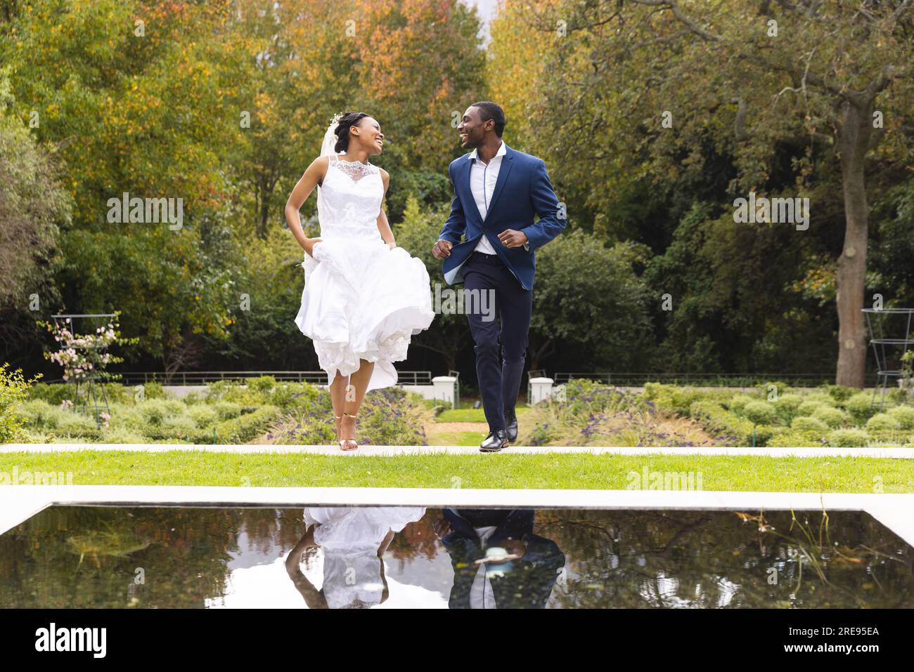 Happy african american bride and groom on wedding day walking together ...