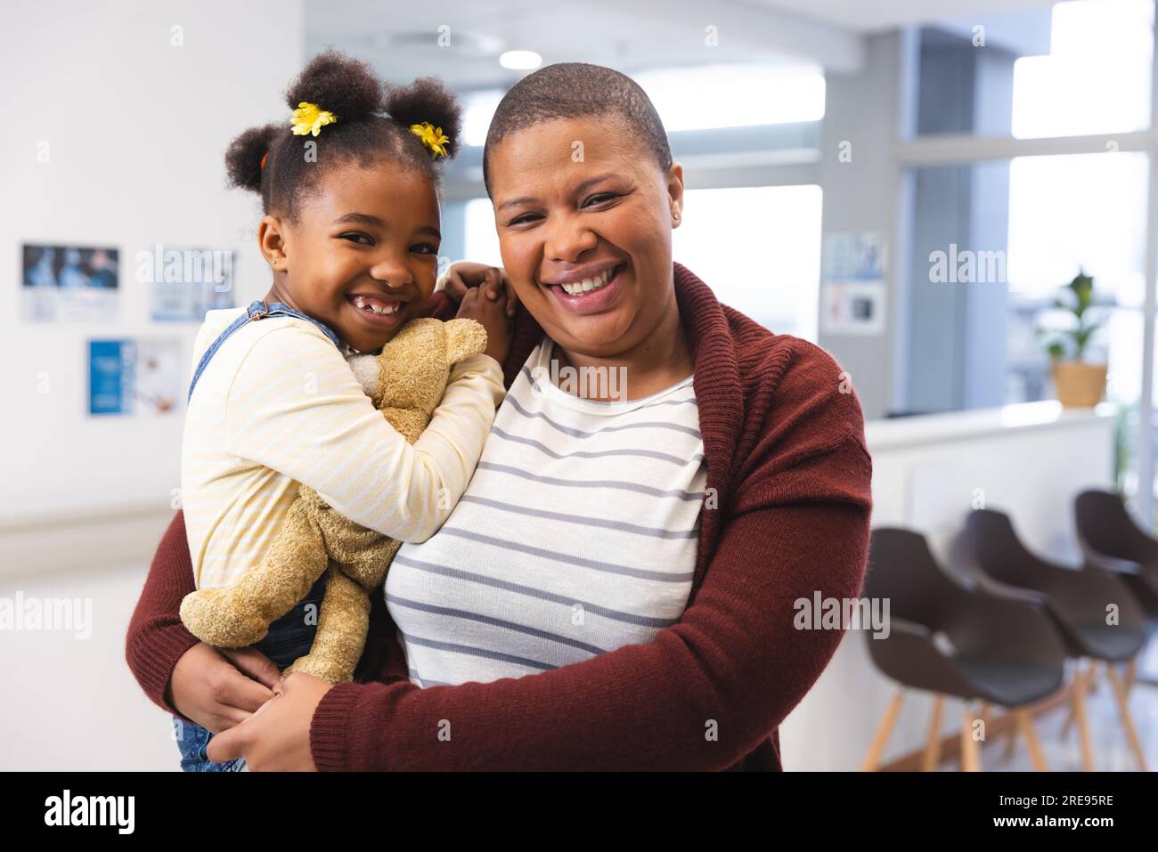 Portrait of happy african american mother and daughter in waiting room at hospital Stock Photo ...
