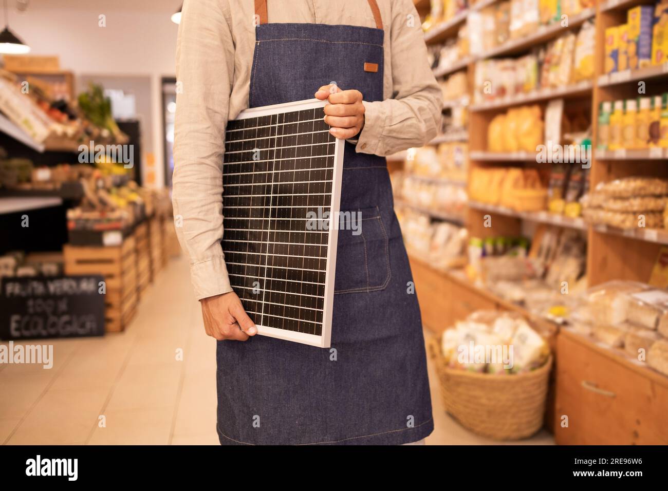 Cropped unrecognizable seller male in casual clothes and apron standing ...