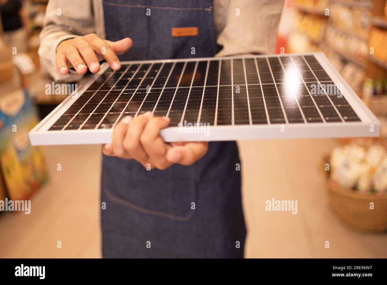 Cropped unrecognizable seller male in casual clothes and apron standing ...