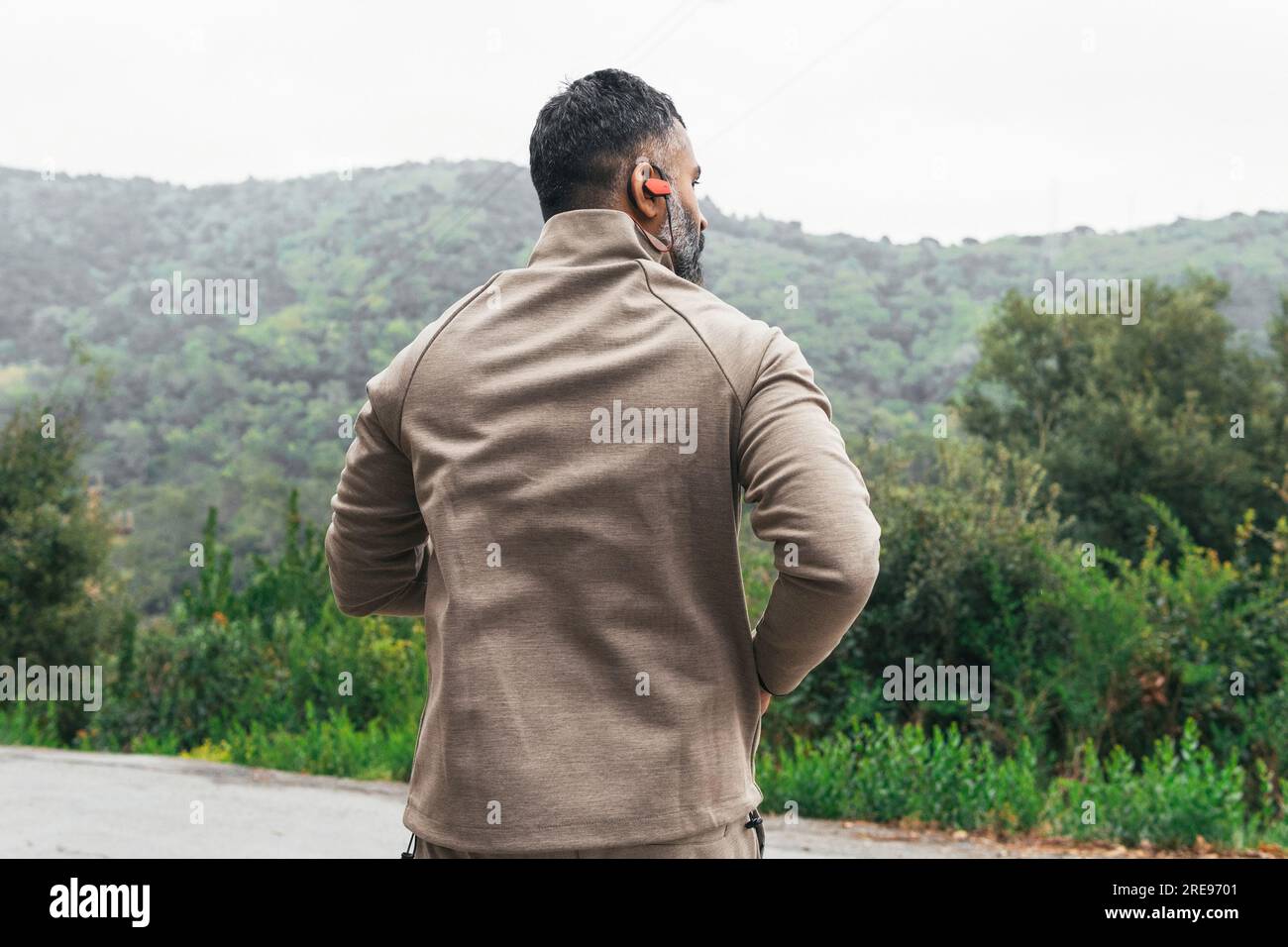 Back view man with sportswear and distracted gesture running along a ...