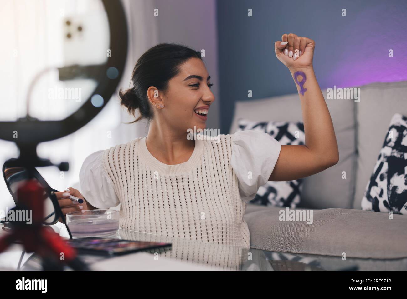 Positive young Hispanic influencer recording video on smartphone while ...