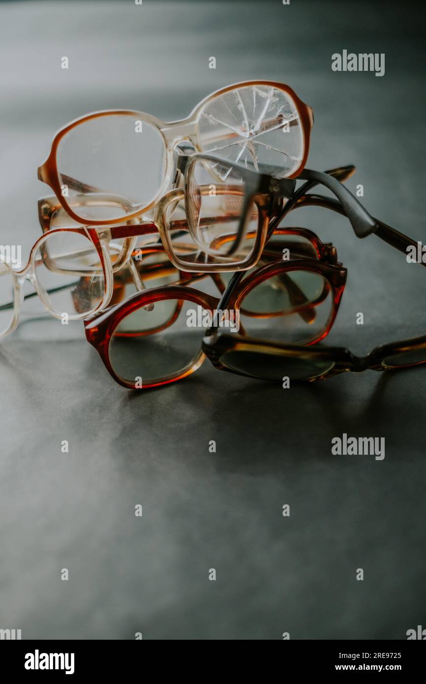 High angle of stack of broken stylish eyeglasses with red plastic rim ...