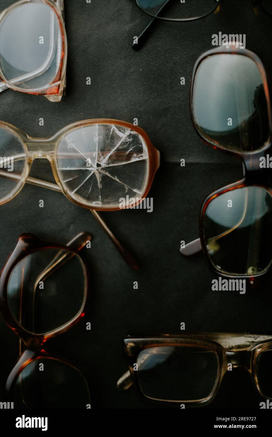 High angle of stack of broken stylish eyeglasses with red plastic rim ...