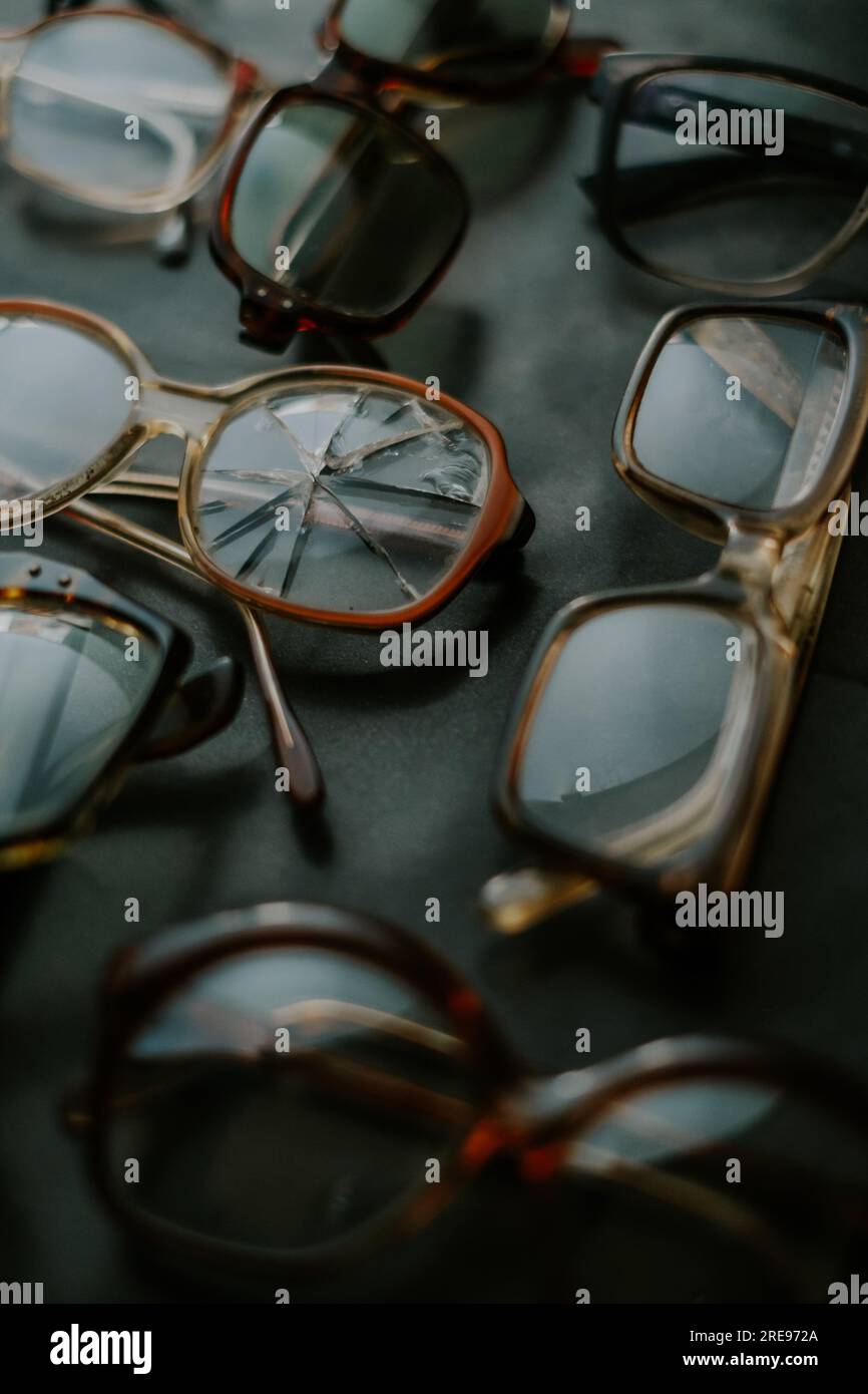 From above of stack of broken stylish eyeglasses with red plastic rim ...