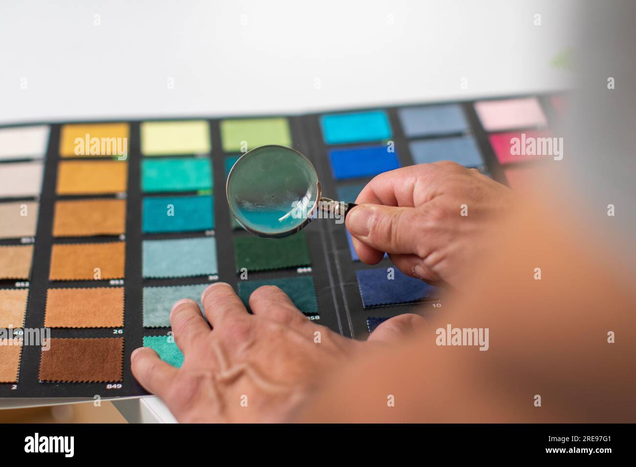 From above of anonymous male worker using magnifying glass while ...