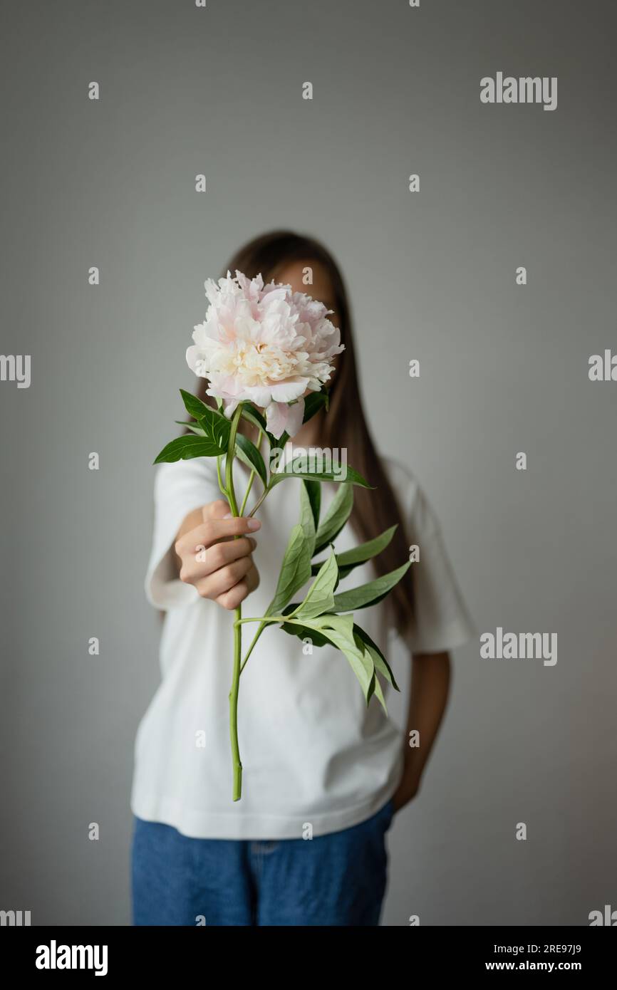 Anonymous preteen child in casual dress while standing hiding behind ...