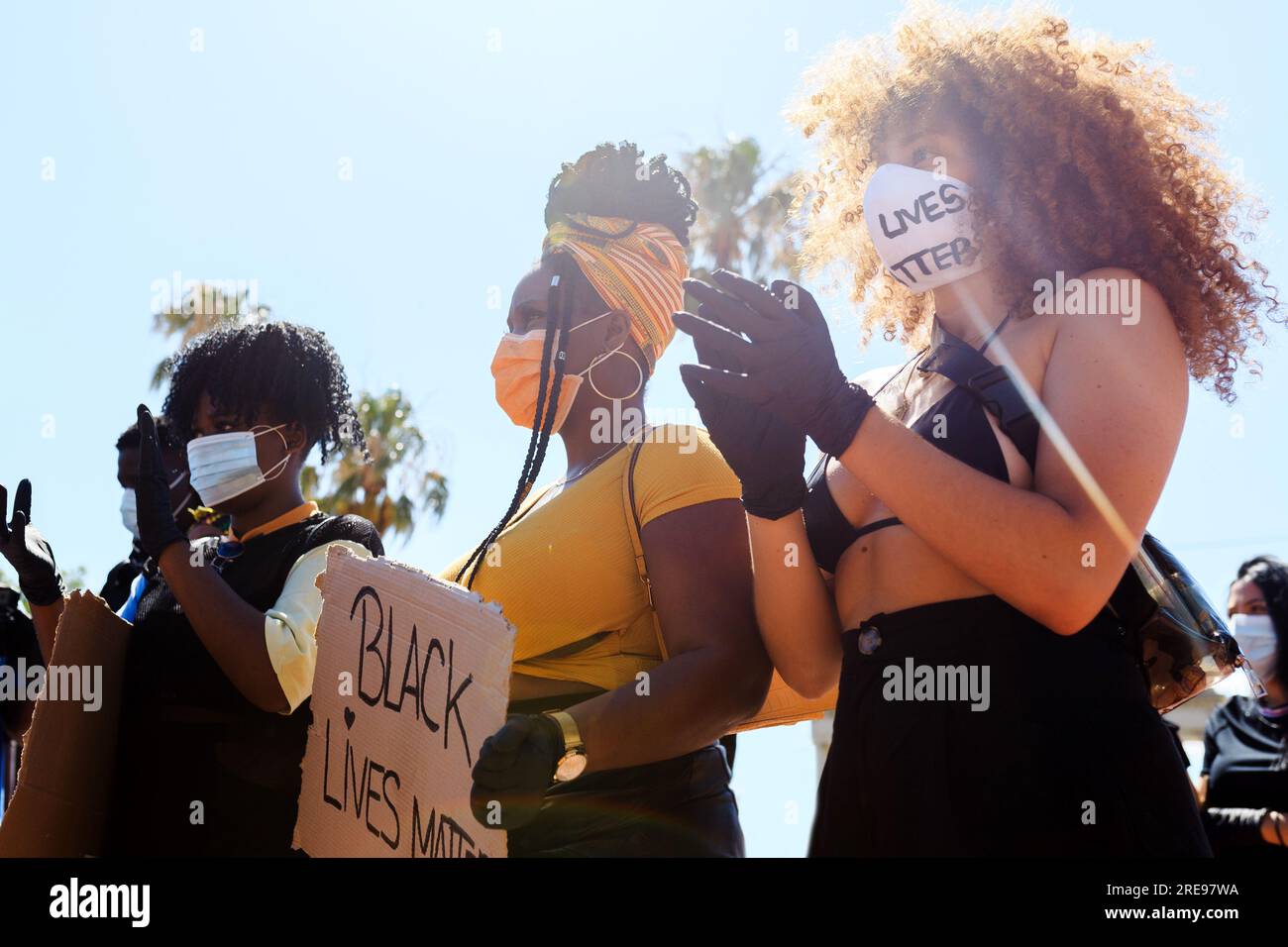 Serious ethnic female with afro hairstyle holding cardboard poster with ...