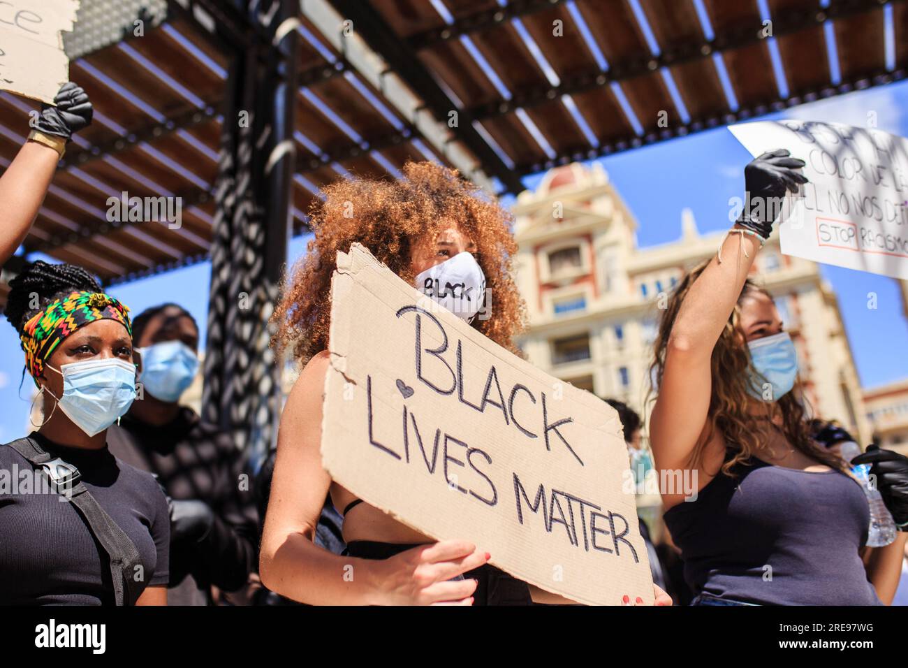 Serious ethnic female with afro hairstyle holding cardboard poster with ...