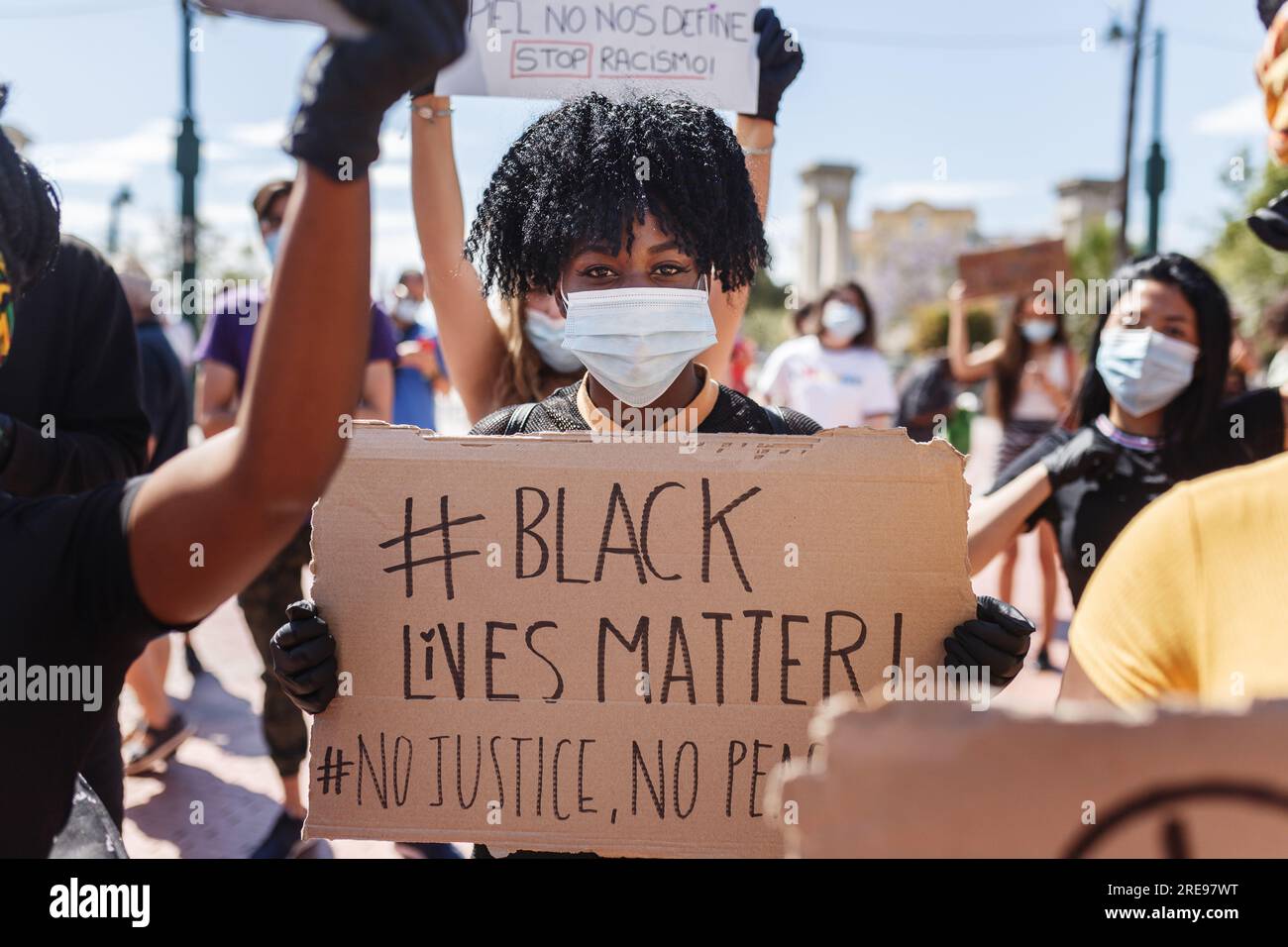 Serious ethnic female with afro hairstyle holding cardboard poster with ...