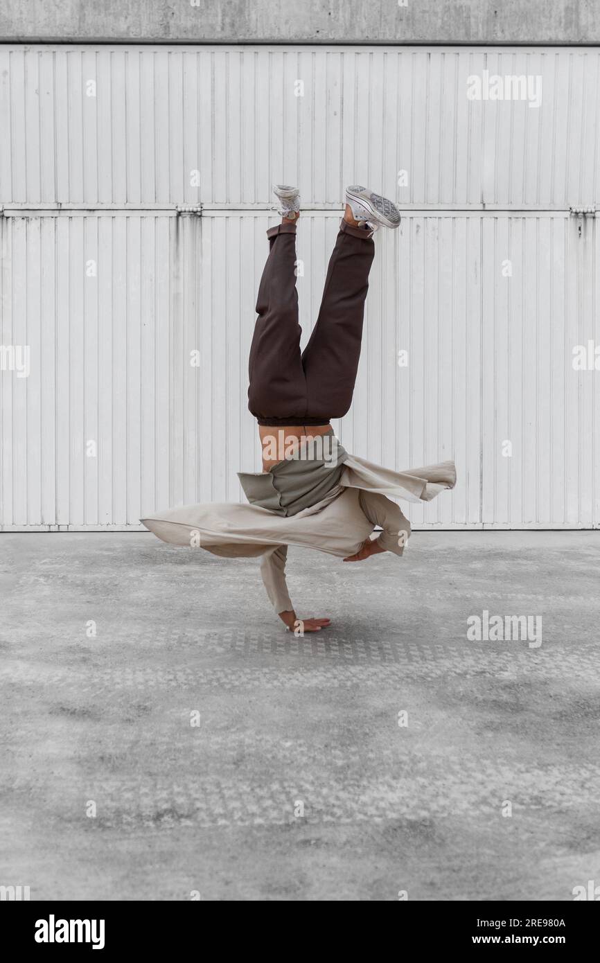 Unrecognizable male dancer showing breakdance movement while balancing ...