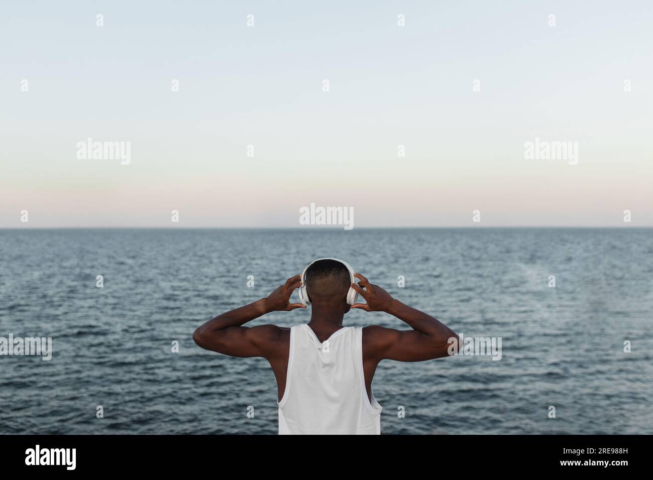 Full body back view of African American runner warming up before ...