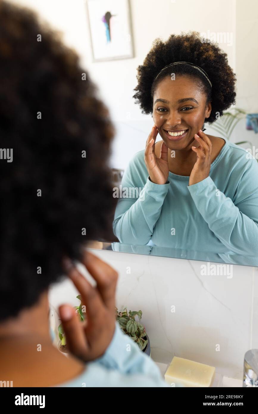Happy Plus Size African American Woman Looking At Face In Mirror In