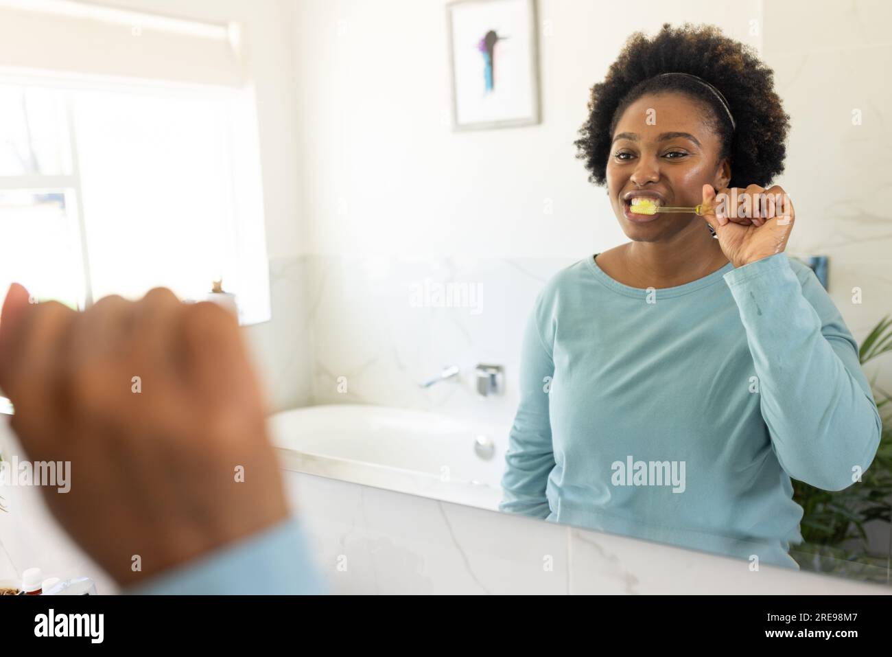 Happy plus size african american woman brushing teeth in bathroom Stock ...