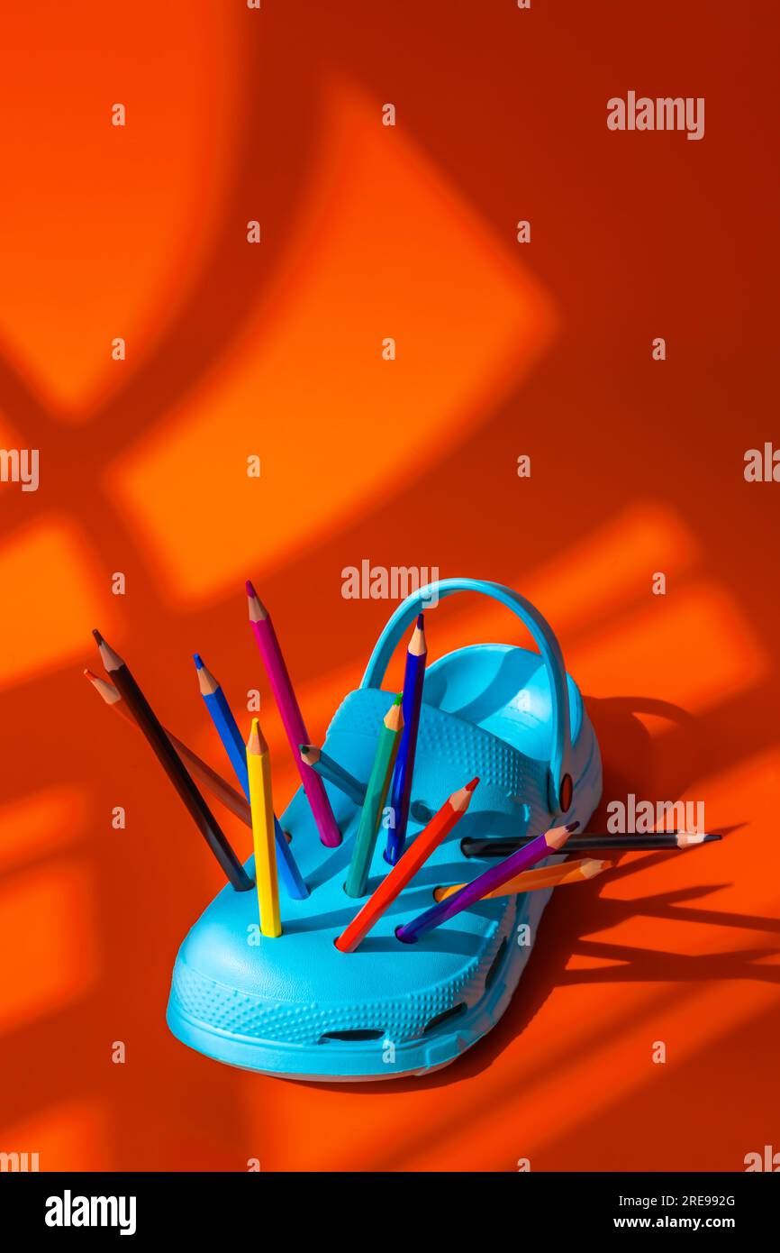 High angle of colorful pencils inserted into the holes of bright blue ...