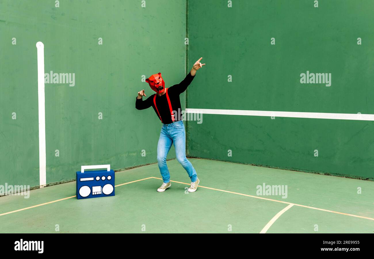 Full body of anonymous male wearing animal mask while dancing near ...