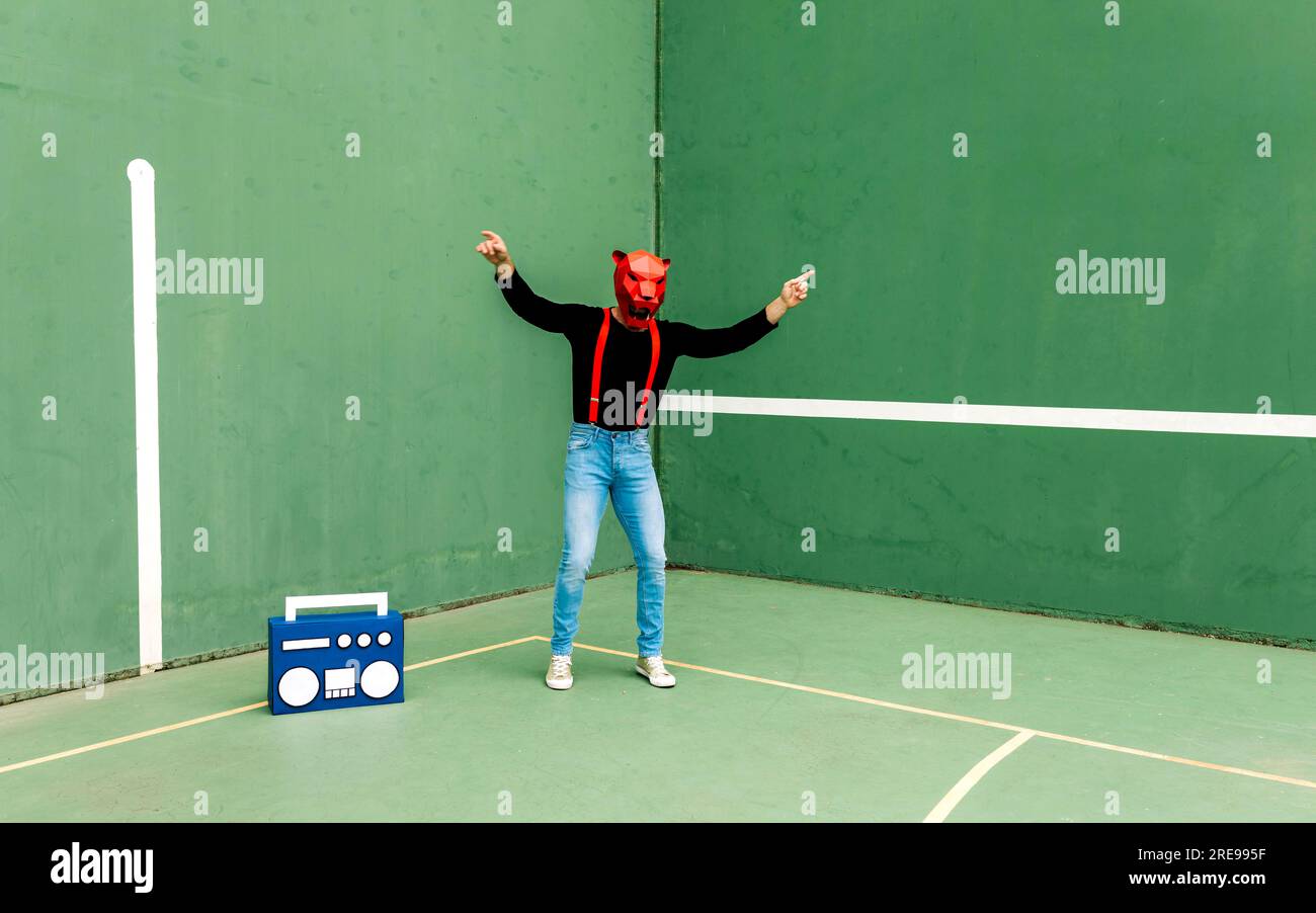 Full body of anonymous male wearing animal mask while dancing with ...