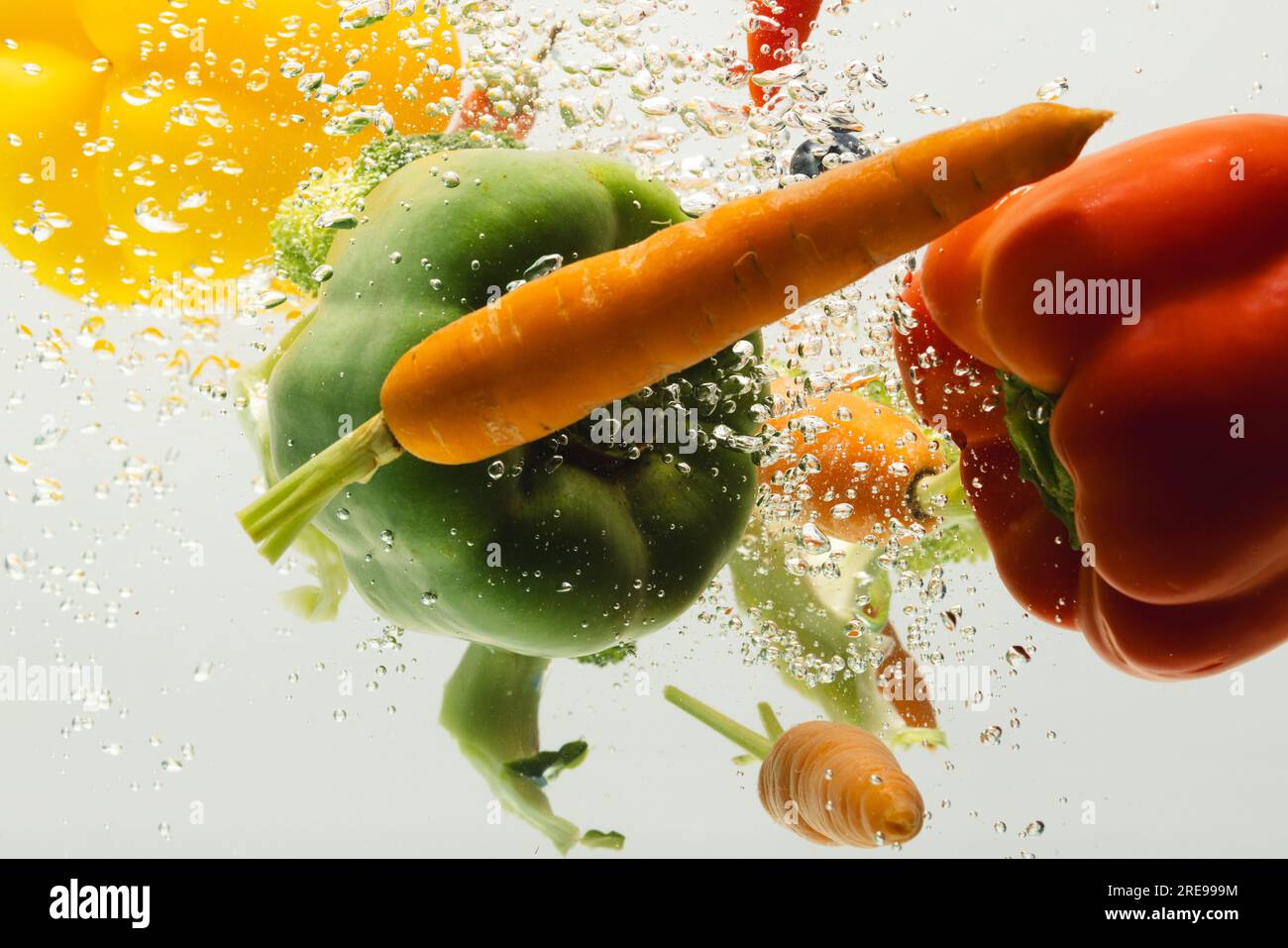 Close up of fresh vegetables falling into water with copy space on ...