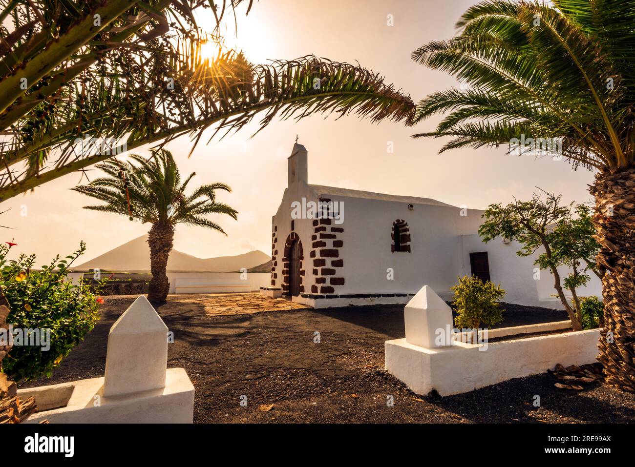 whitewashed church in Lanzarote with a volcano in the background Stock ...