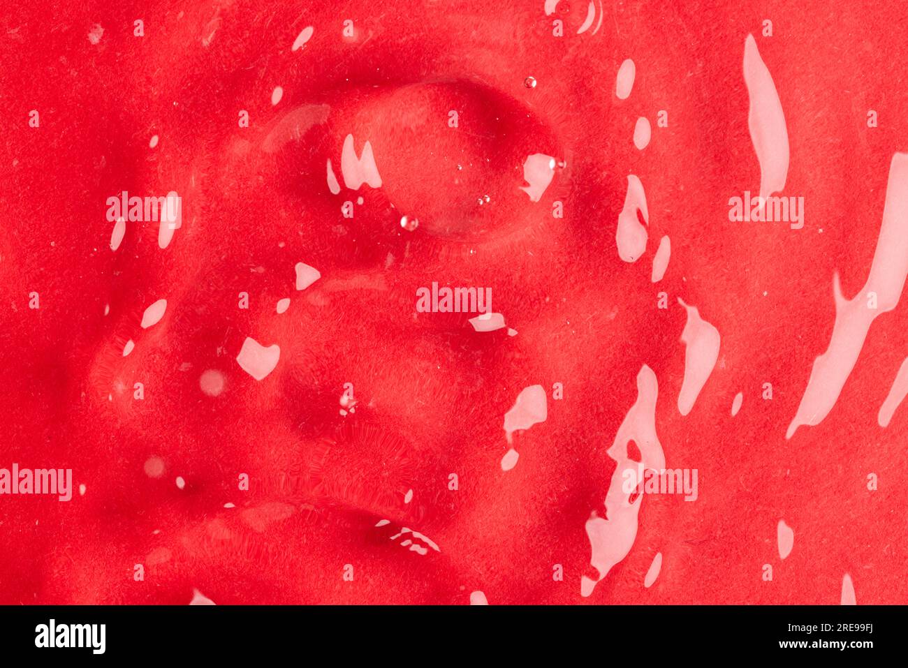 Close up of water ripples and waves with copy space on red background ...