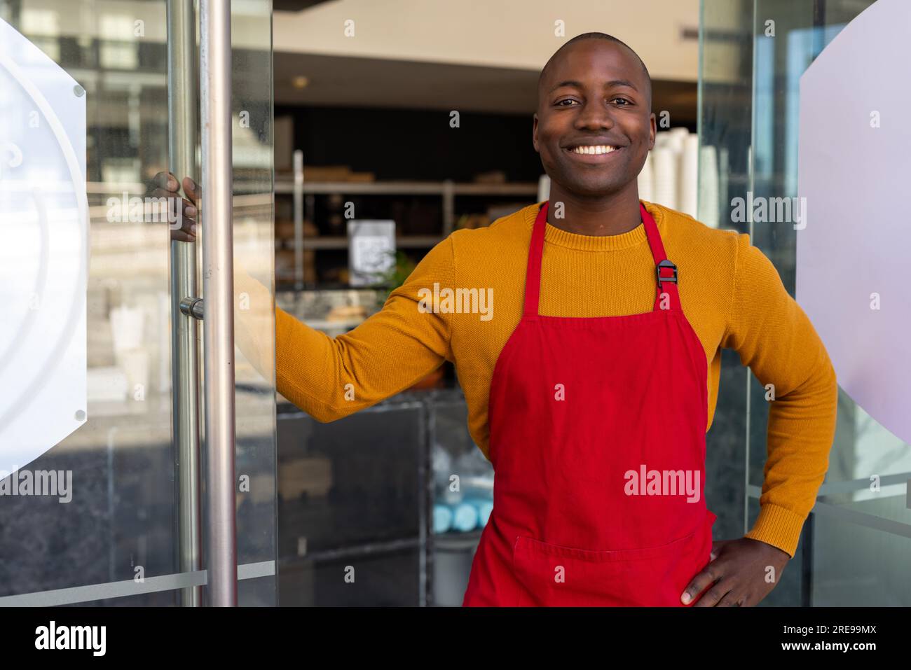 Portrait of happy african american male bakery worker wearing red apron ...