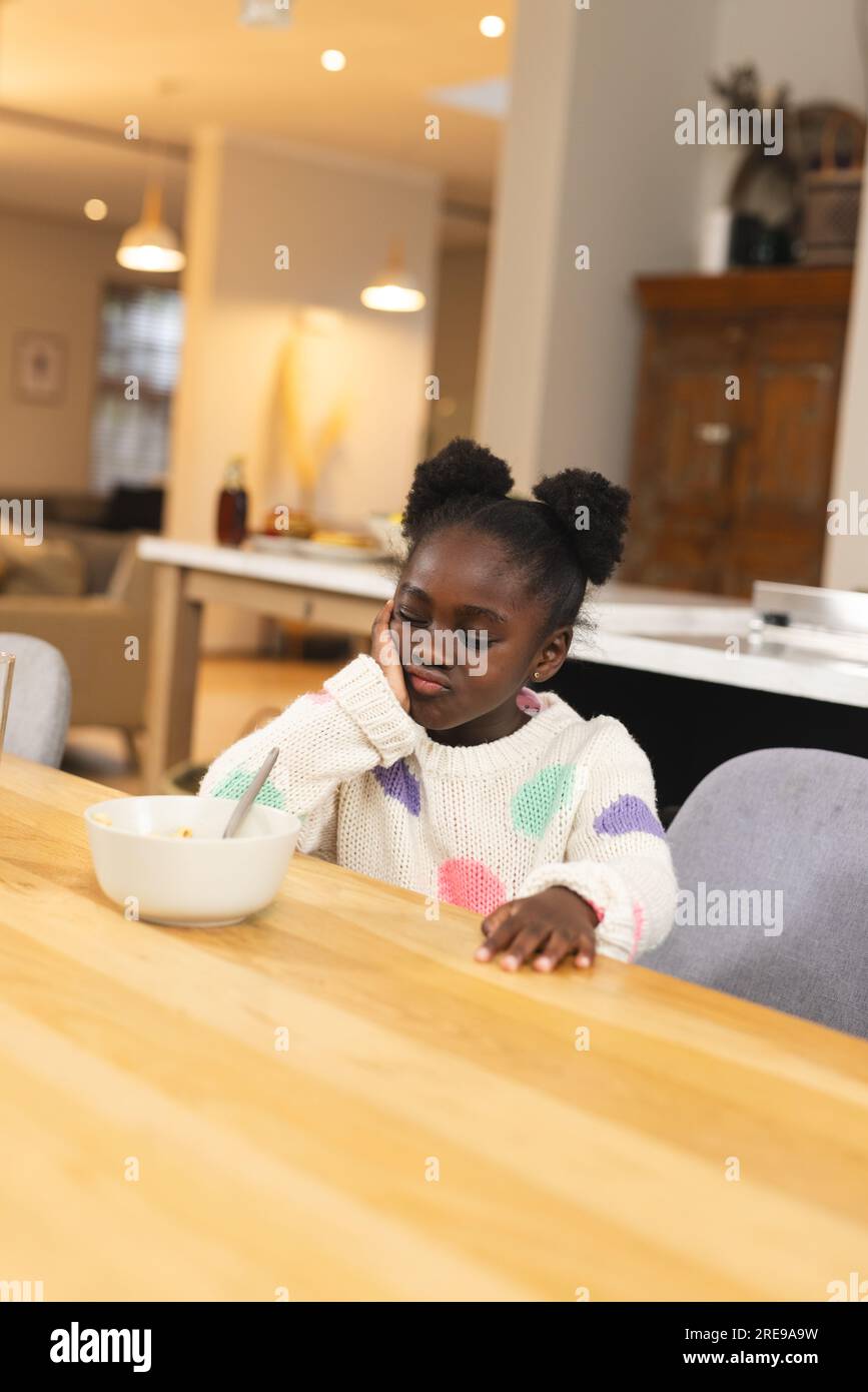 Sad african american girl sitting at table eating breakfast Stock Photo ...