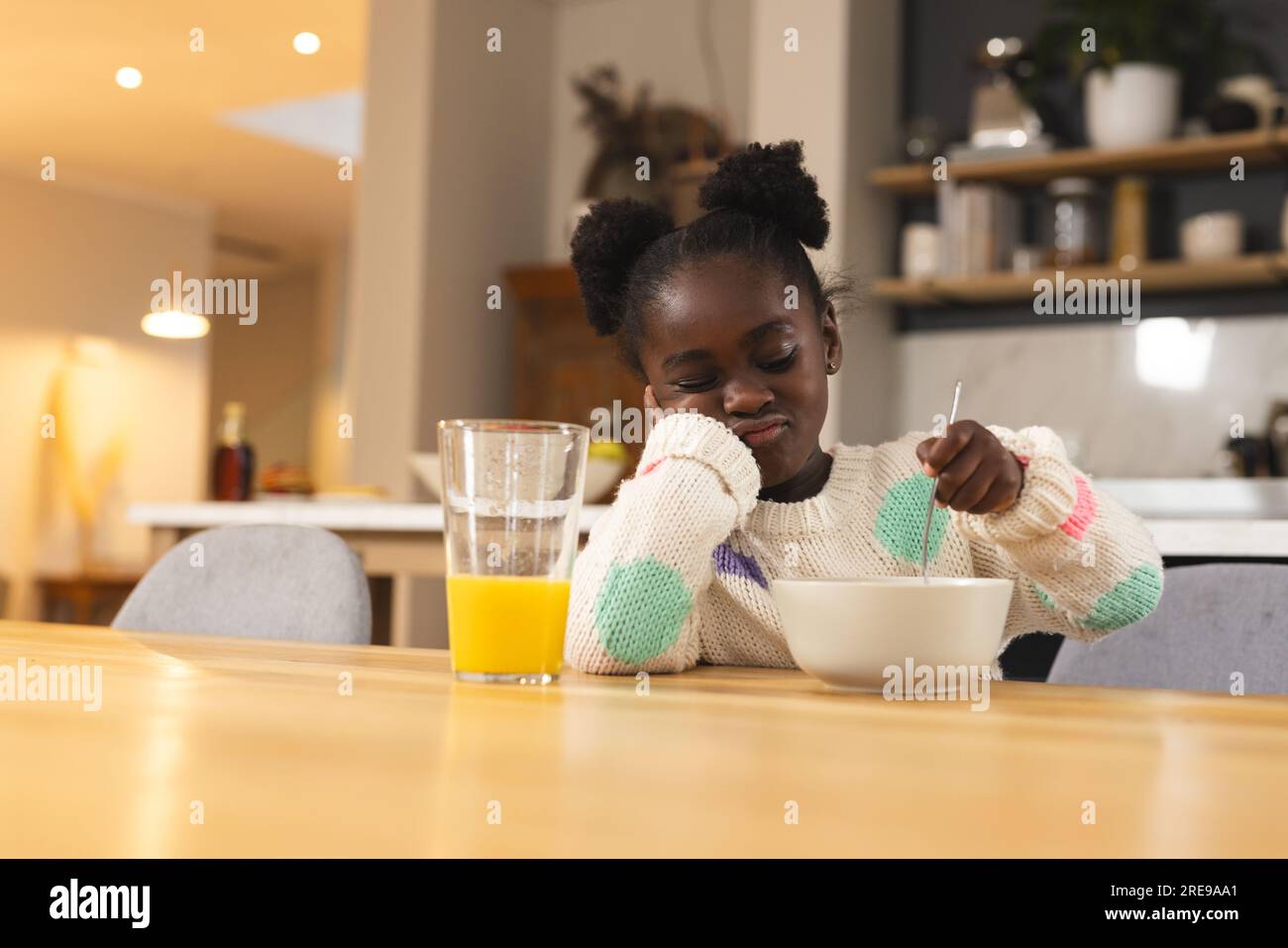 Sad african american girl sitting at table eating breakfast Stock Photo ...