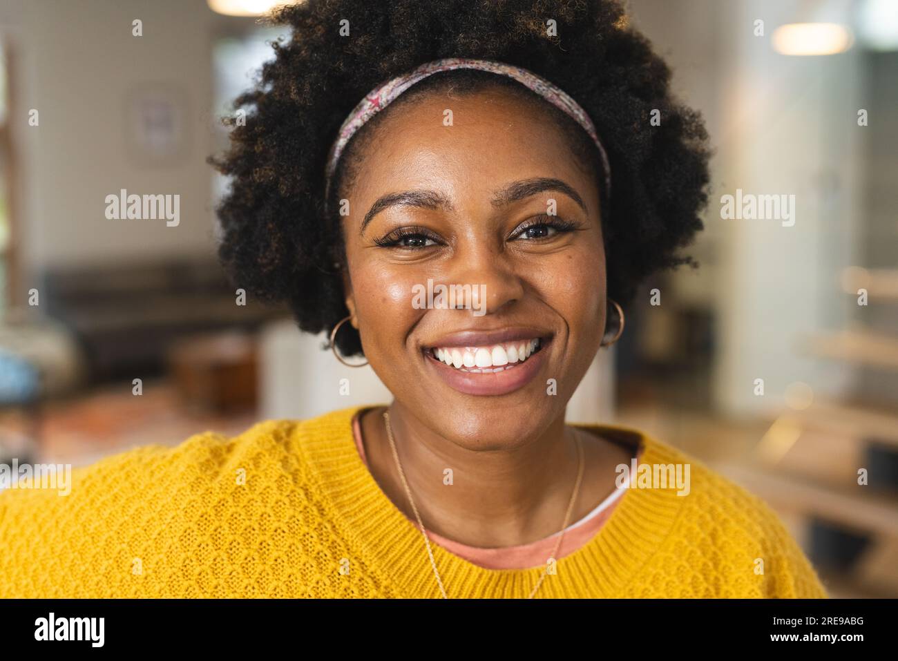 Portrait of happy african american woman wearing yellow sweater smiling ...