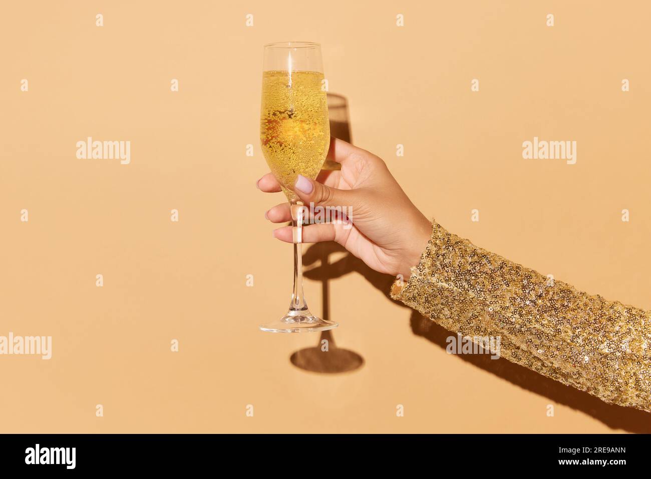 Lady's hand holding glass of shampange with lime and bright straw on ...