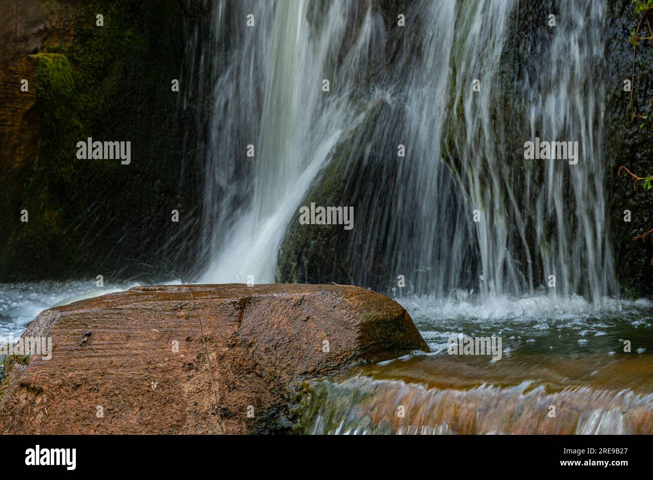 Wet boulder in the middle of the waterfall jets. Close up Stock Photo ...