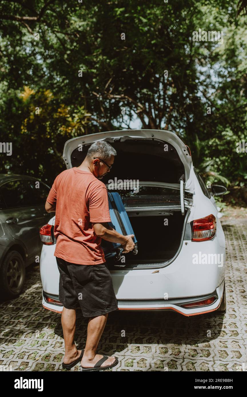 Man pushing trolley luggage bag outdoor Stock Photo - Alamy