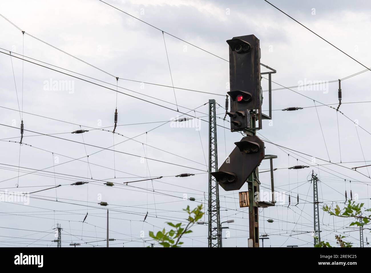 Railway traffic control light with red light against gray cloudy sky ...