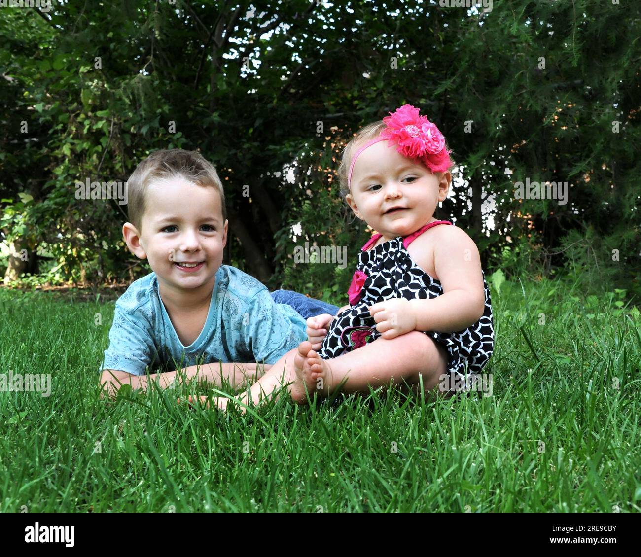 Brother and Sister enjoy each others company. They sit and lay on the ...