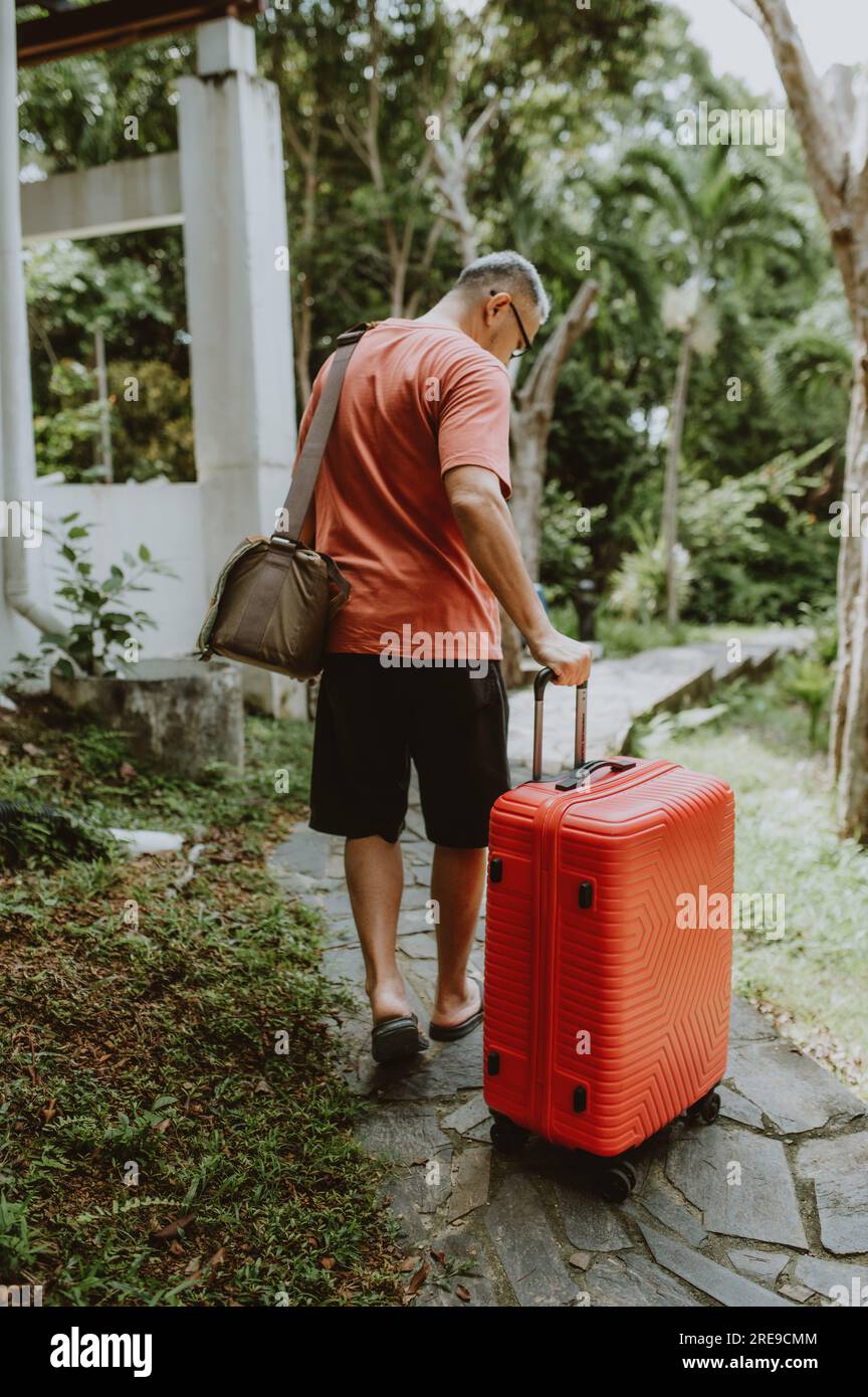 Man pushing trolley luggage bag outdoor Stock Photo - Alamy