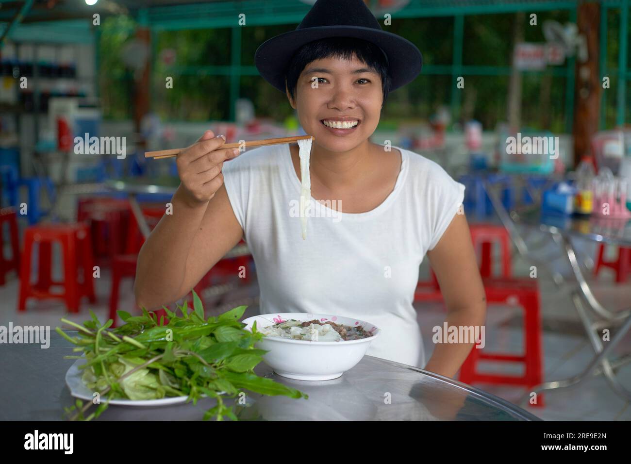 Asian Woman eating Vietnamese Pho Noodle Soup at a restaurant in Ho Chi ...