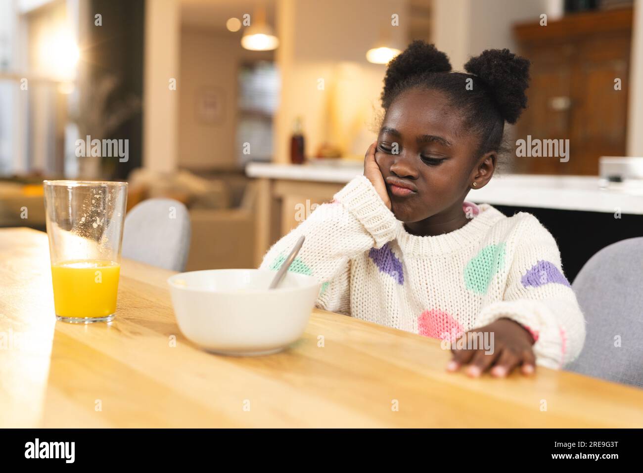 Sad african american girl sitting at table eating breakfast Stock Photo ...