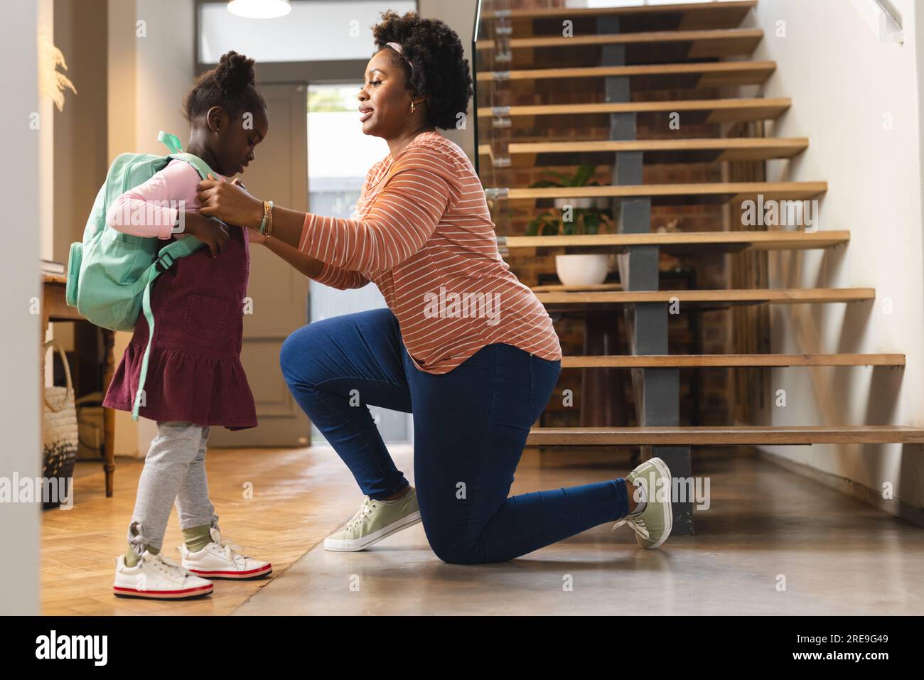 Happy african american mother and daughter embracing before school at home Stock Photo - Alamy