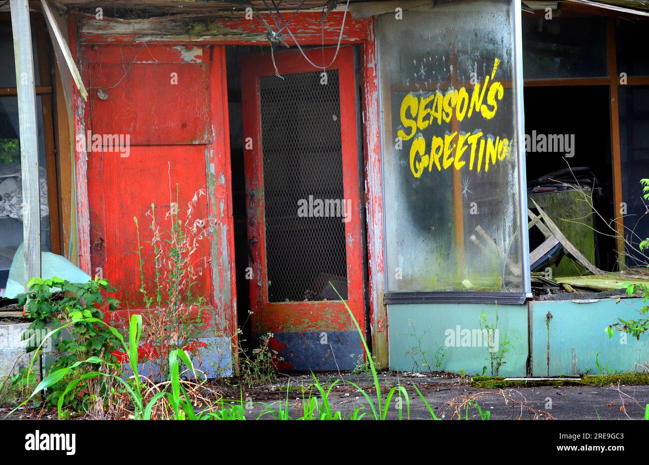 Dilapidated, closed store has its' red doors hanging open. Sign on ...