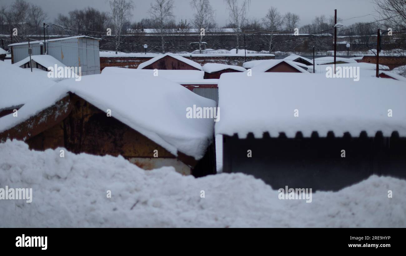 Garages in winter. Garages in snow. Roofs of houses in snow. Winter in ...