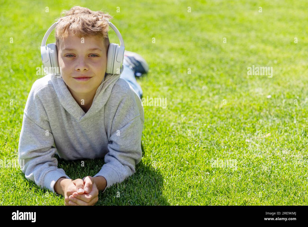 A boy relaxing on grass, listening to music with headphones Stock Photo ...
